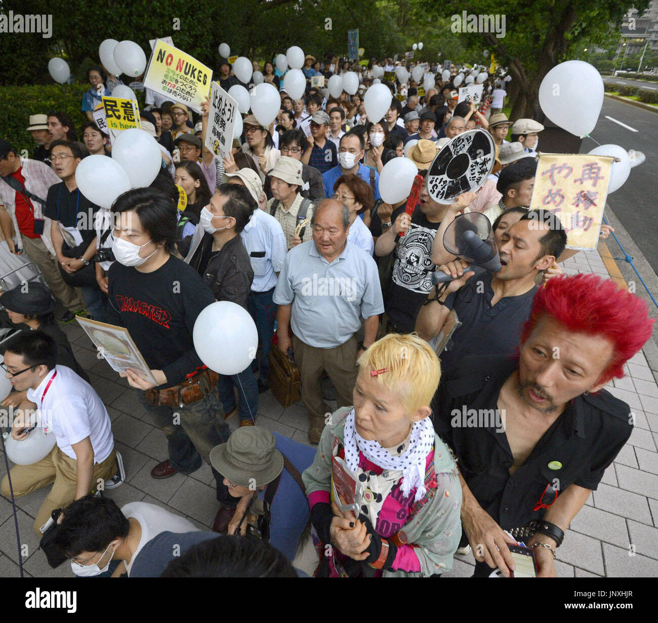 TOKYO, Japan - People, some holding balloons, gather in a demonstration ...