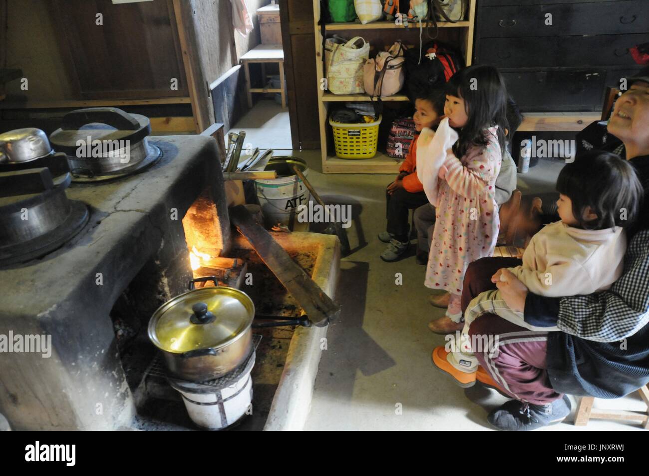 NAGOYA, Japan - Children warm up in an old longhouse in the ''Gojikara ...