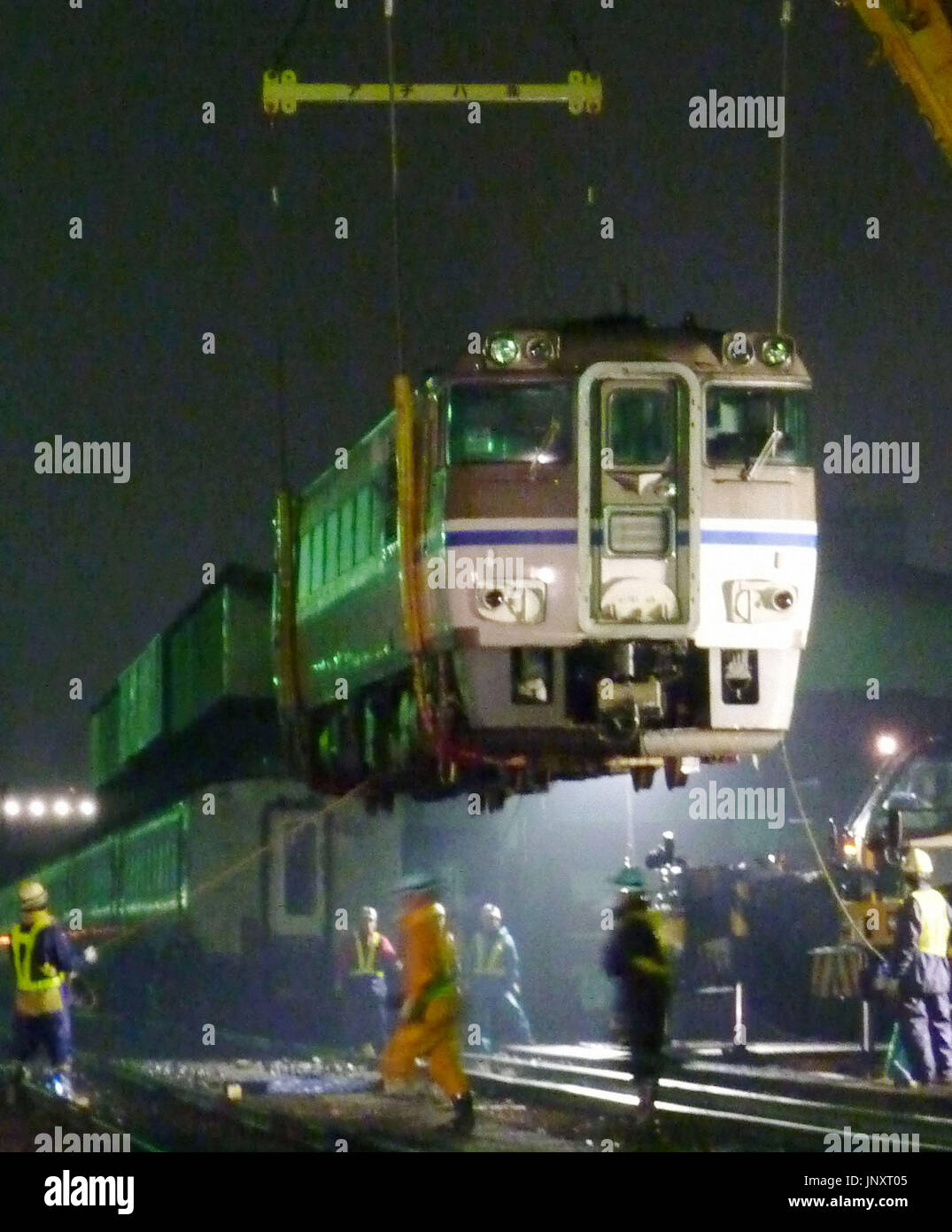 KITAKYUSHU, Japan - A diesel-powered train is lifted for transportation ...
