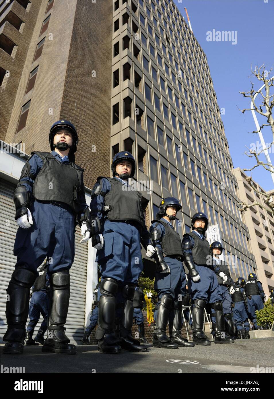 TOKYO, Japan - Riot police officers stand guard next to a building ...