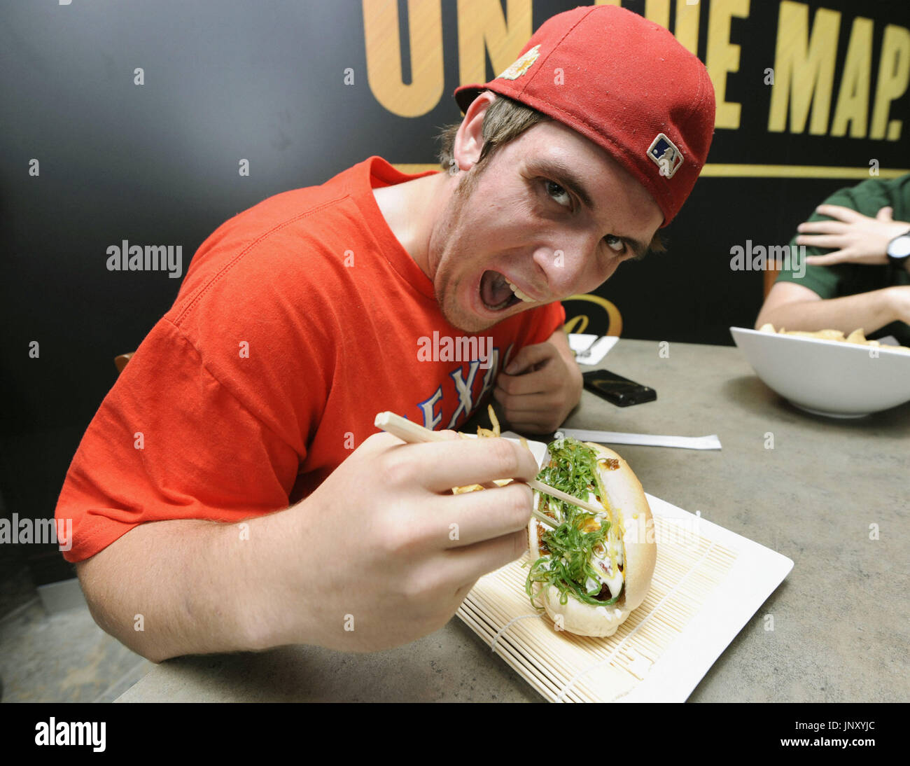 ARLINGTON, United States - A Texas Rangers fan eats a Yu Dog, a hot dog ...