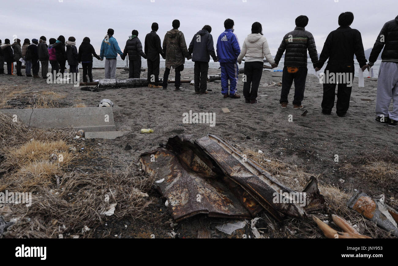 MINAMISANRIKU, Japan - People line up and hold hands to mourn for the ...
