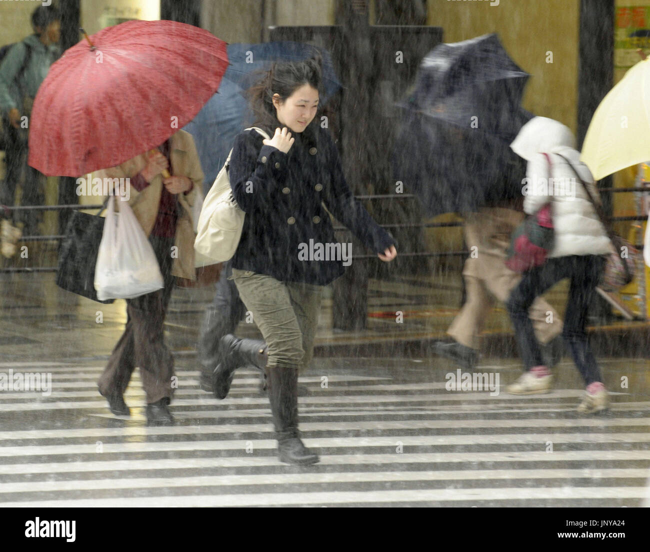 OSAKA, Japan - Heavy rain and strong winds have pedestrians rushing in ...