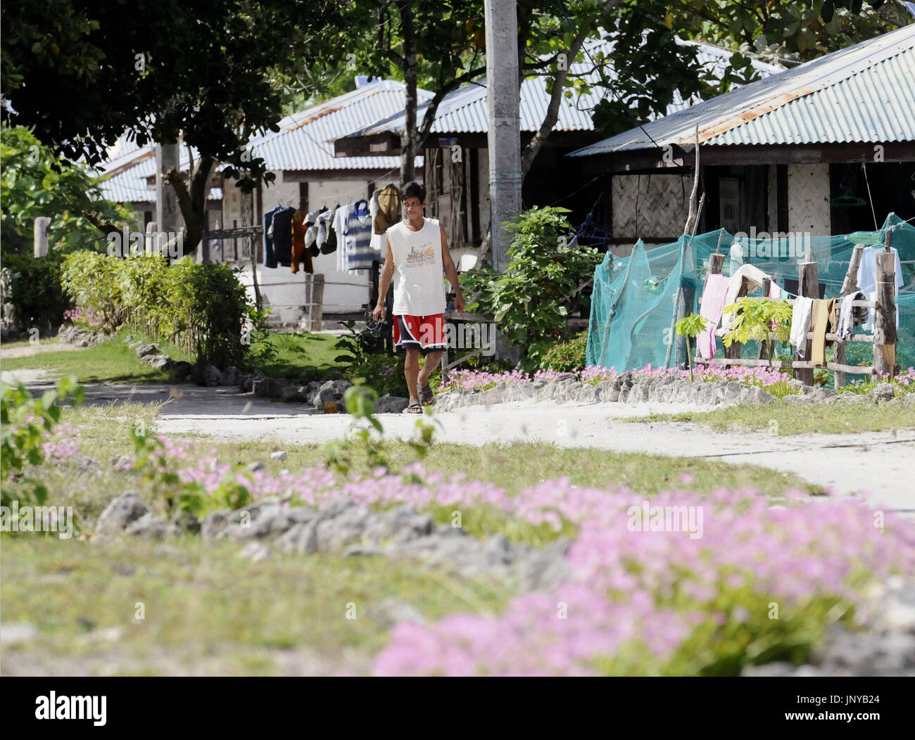 THITU ISLAND, Spratly Islands - A man walks in a residential area on ...