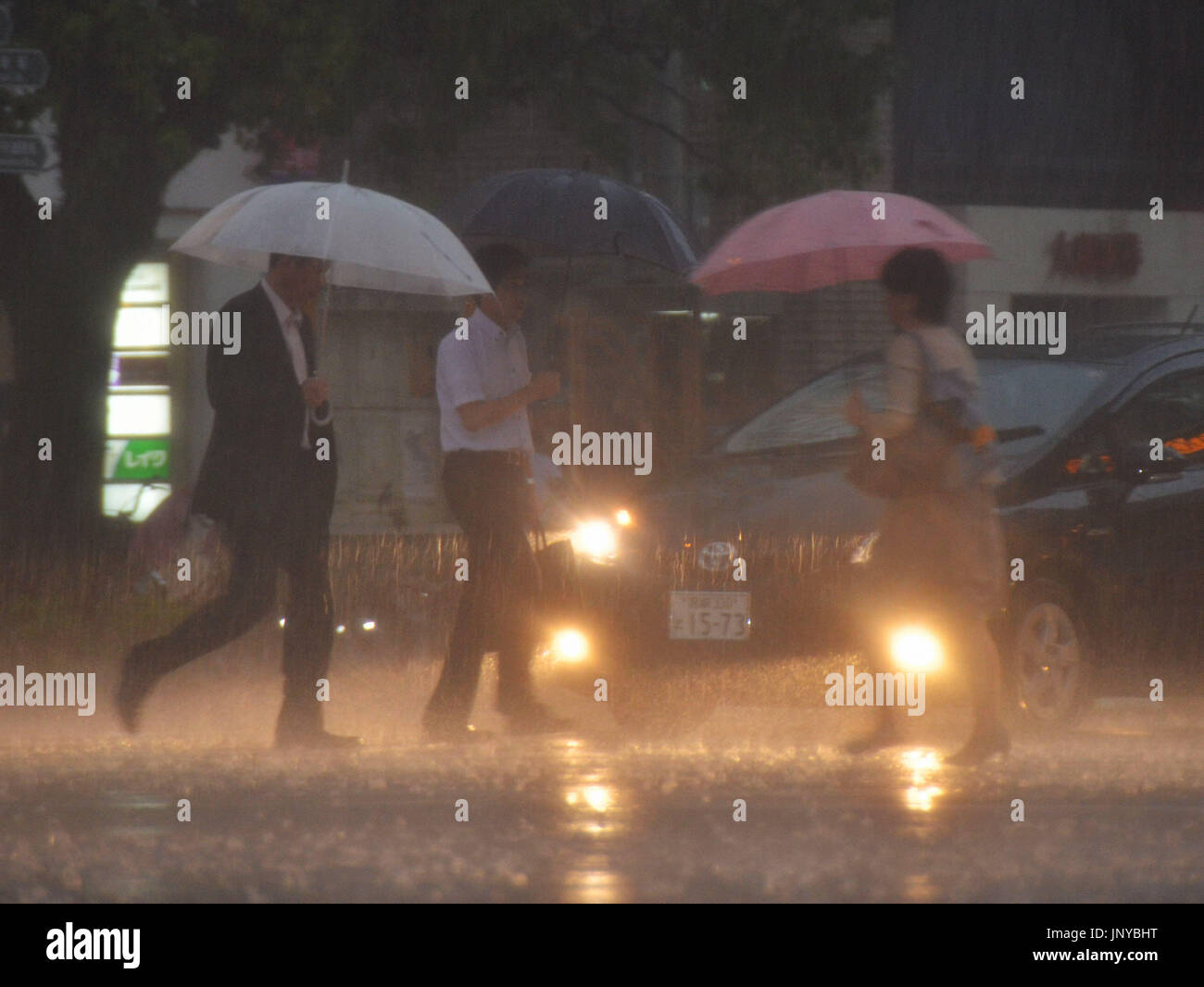 MIYAZAKI, Japan - People cross an intersection in rain in Miyazaki ...