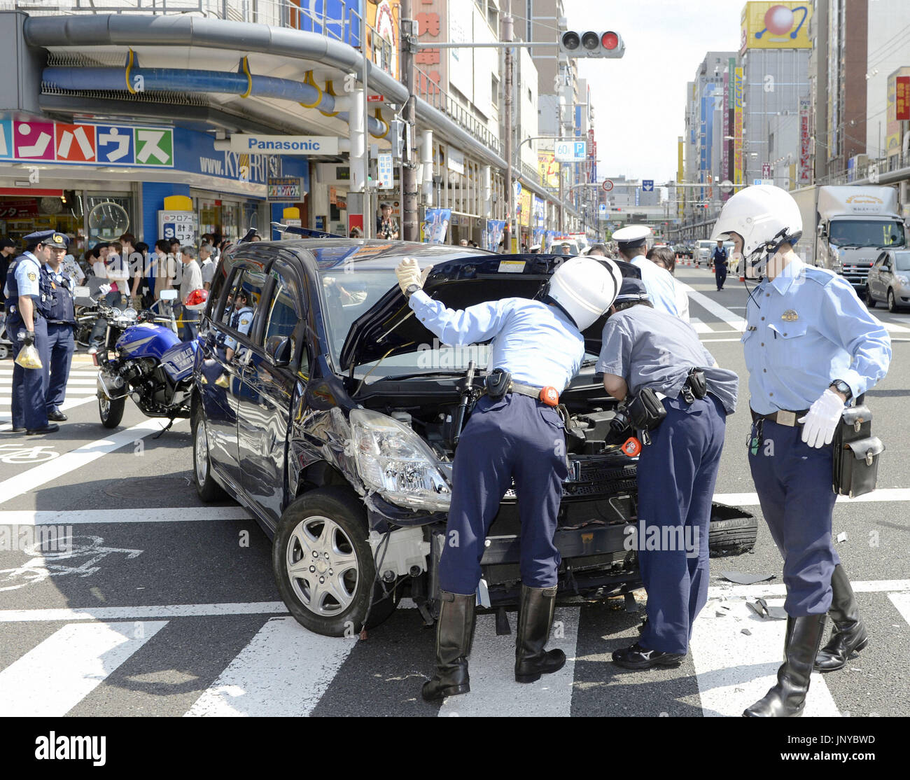 OSAKA, Japan - Police officers examine a damaged minivan on a street in ...