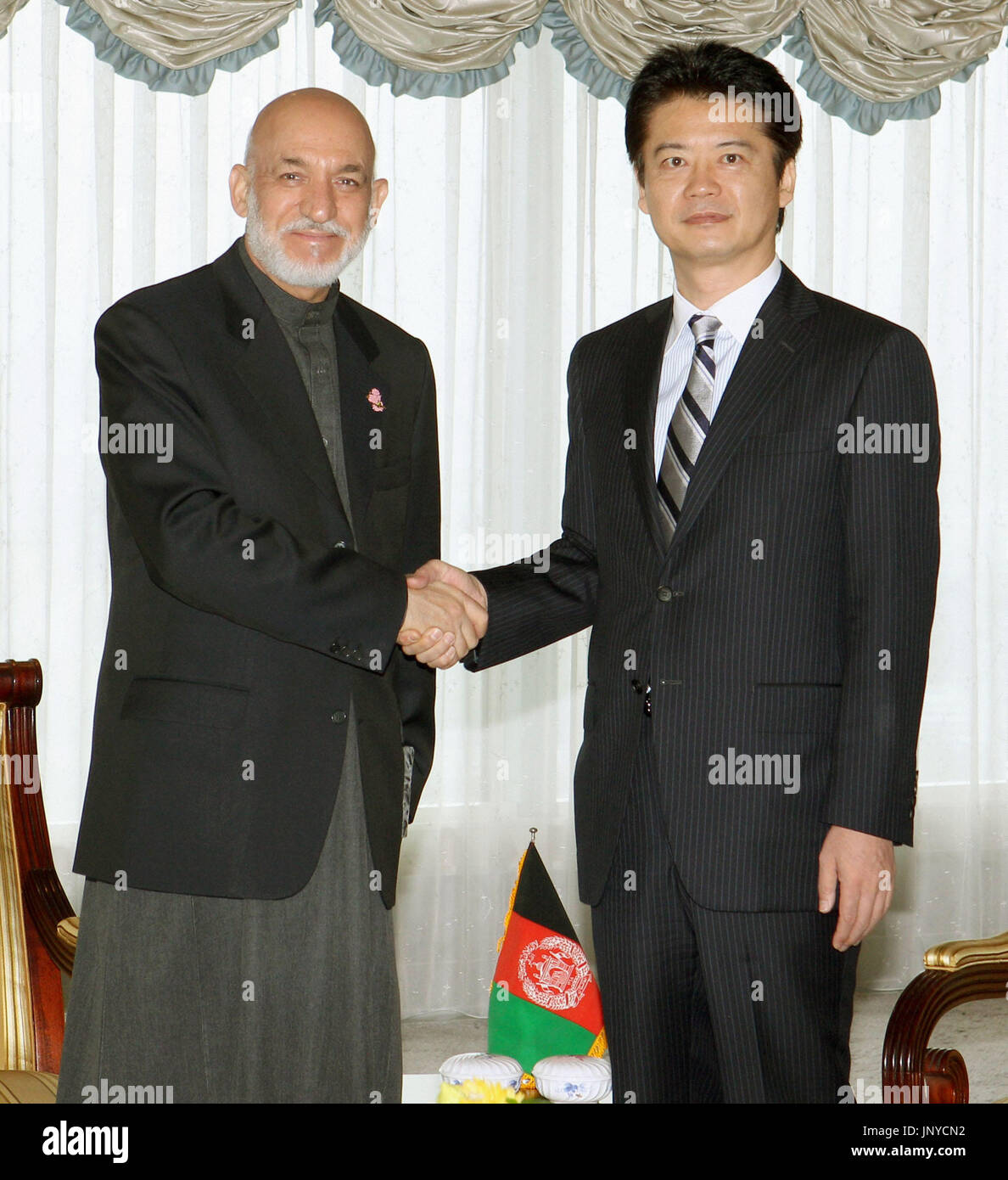 TOKYO, Japan - Afghan President Hamid Karzai (L) shakes hands with ...