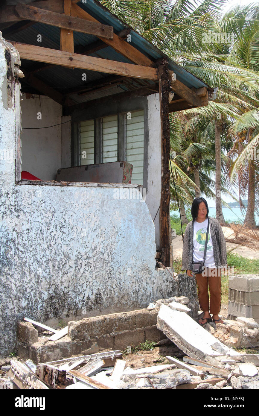 GUIWAN, Philippines - A resident examines her home in Guiwan on Samar ...