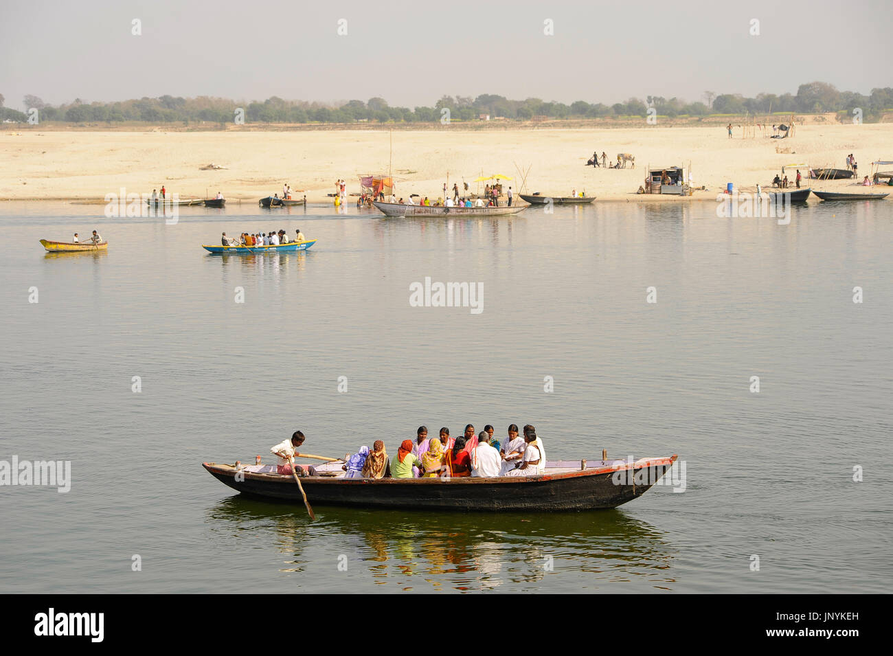 A group of Indian men and women on a rowing boat in the Ganges, with ...