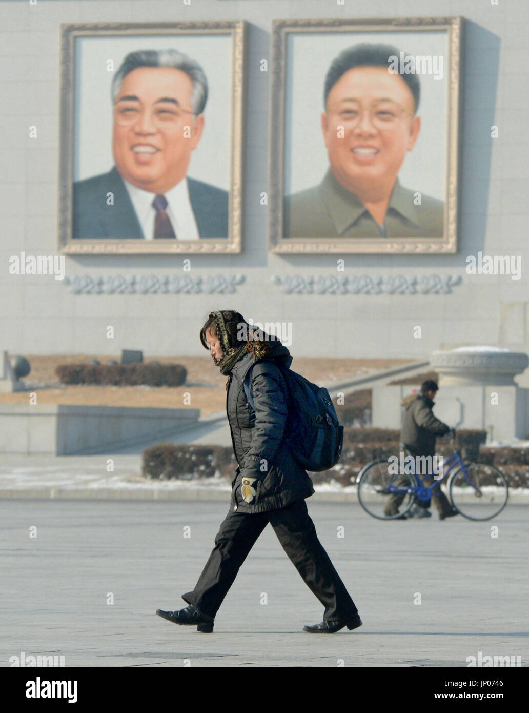 PYONGYANG, North Korea - A citizen walks past portraits of North Korean ...