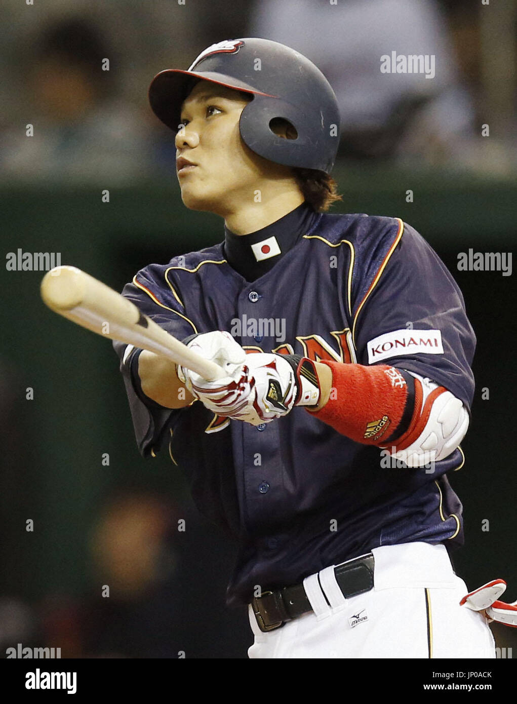 TOKYO, Japan - Hayato Sakamoto of Japan watches the ball after hitting ...