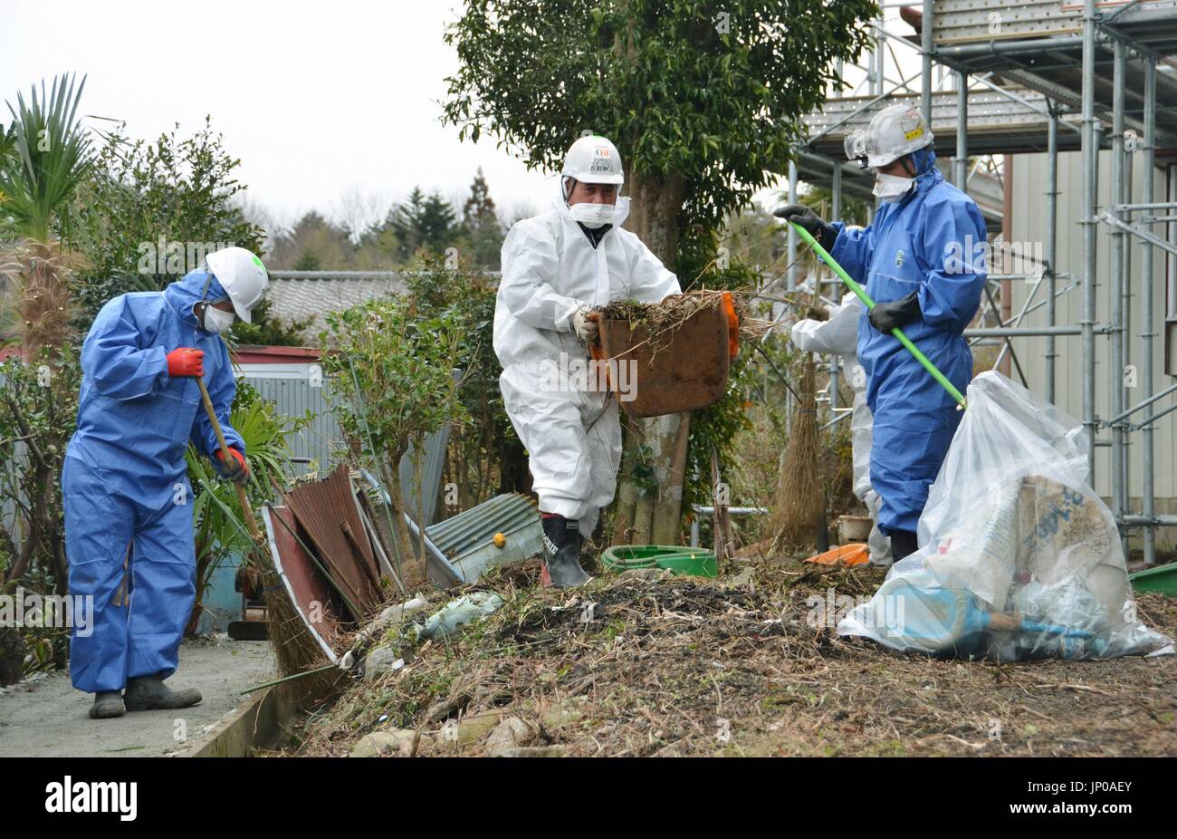 FUKUSHIMA, Japan - Workers engage in decontamination of a residential neighborhood in restricted ...