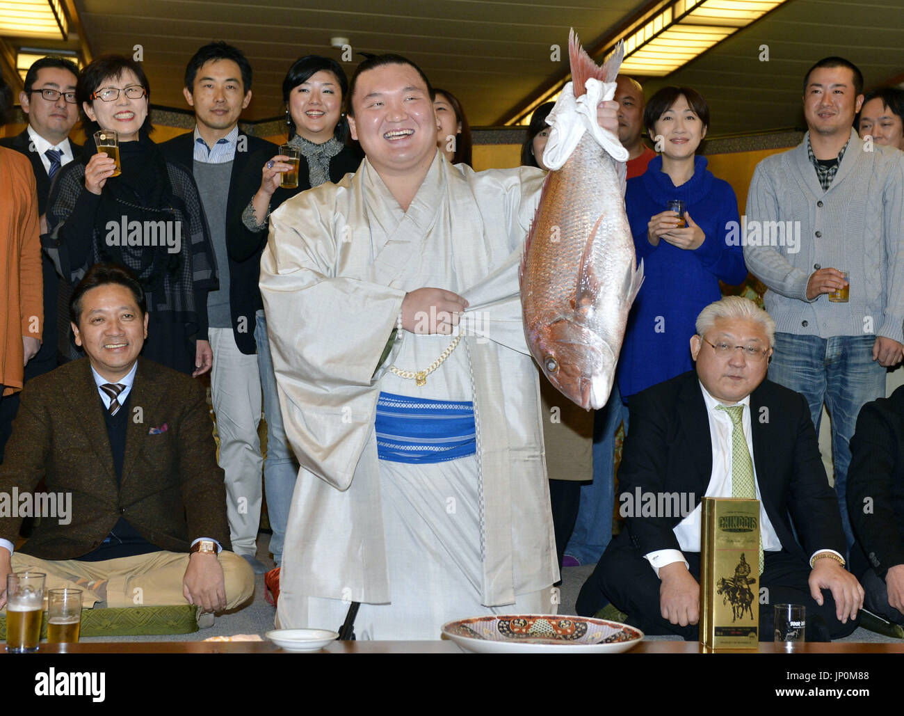 FUKUOKA, Japan - Mongolian grand champion Hakuho (C) holds a sea bream ...