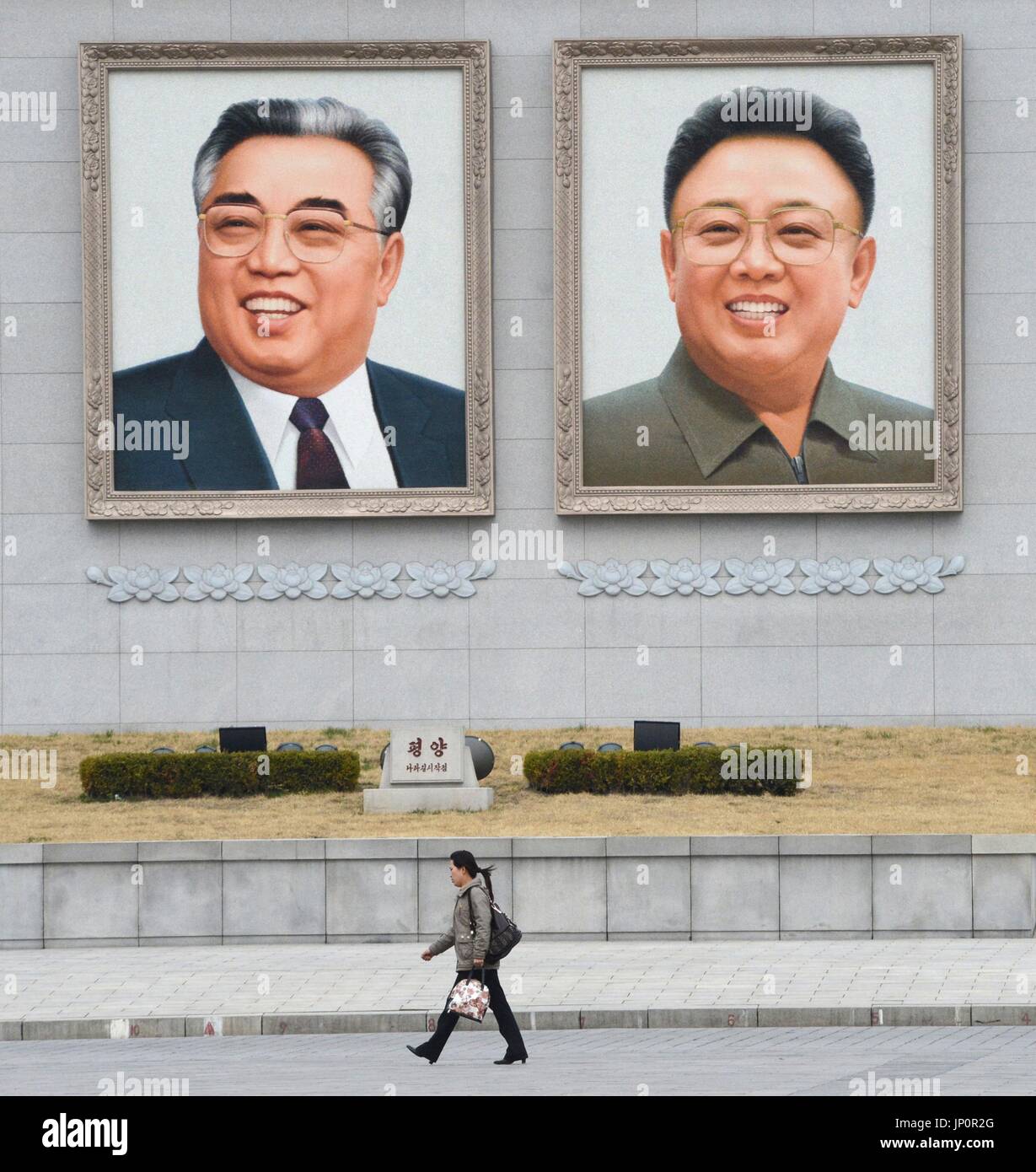 PYONGYANG, North Korea - A citizen walks past portraits of North Korean ...