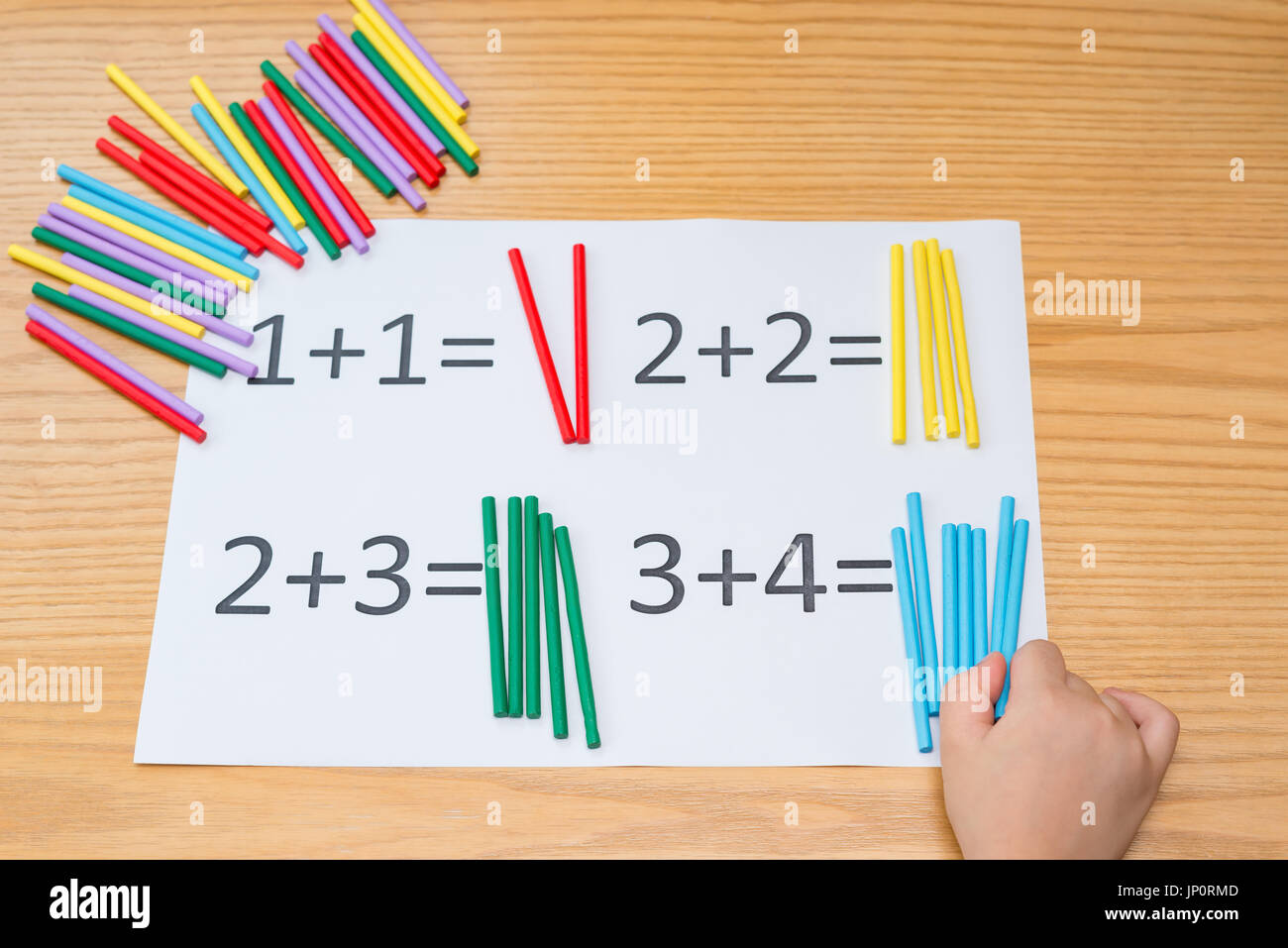 kid learning simple addition by counting numbers of sticks Stock Photo ...