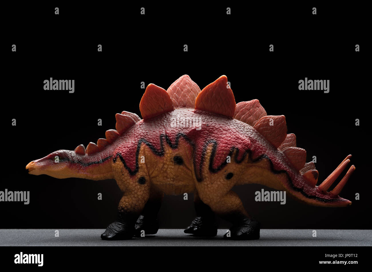 side view brown stegosaurus toy on a dark background Stock Photo - Alamy