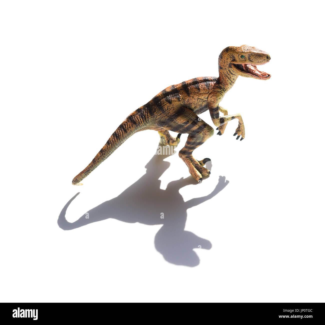 yellow velociraptor toy on a white background with shadow Stock Photo ...