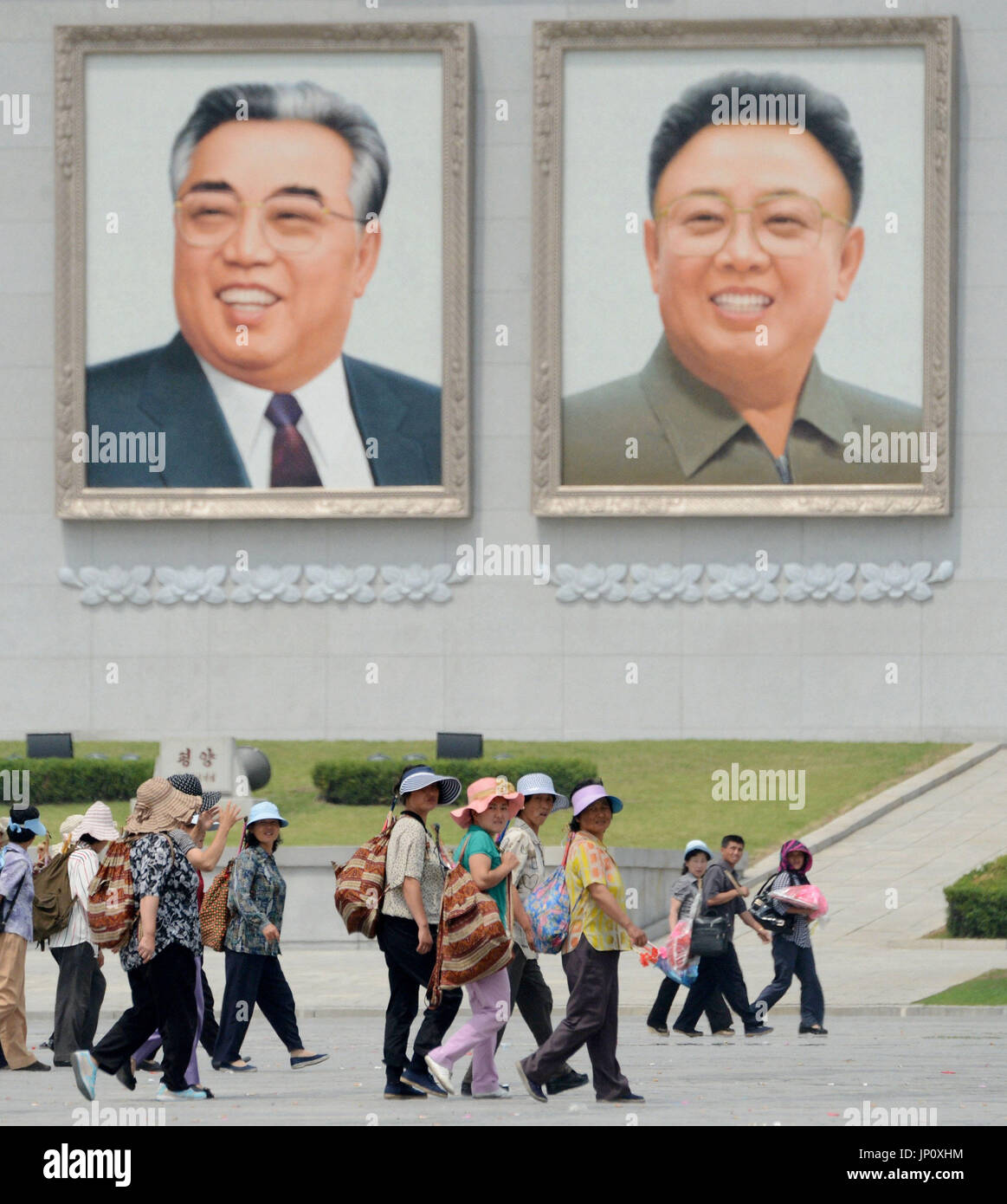 PYONGYANG, North Korea - People walk past portraits of North Korean ...