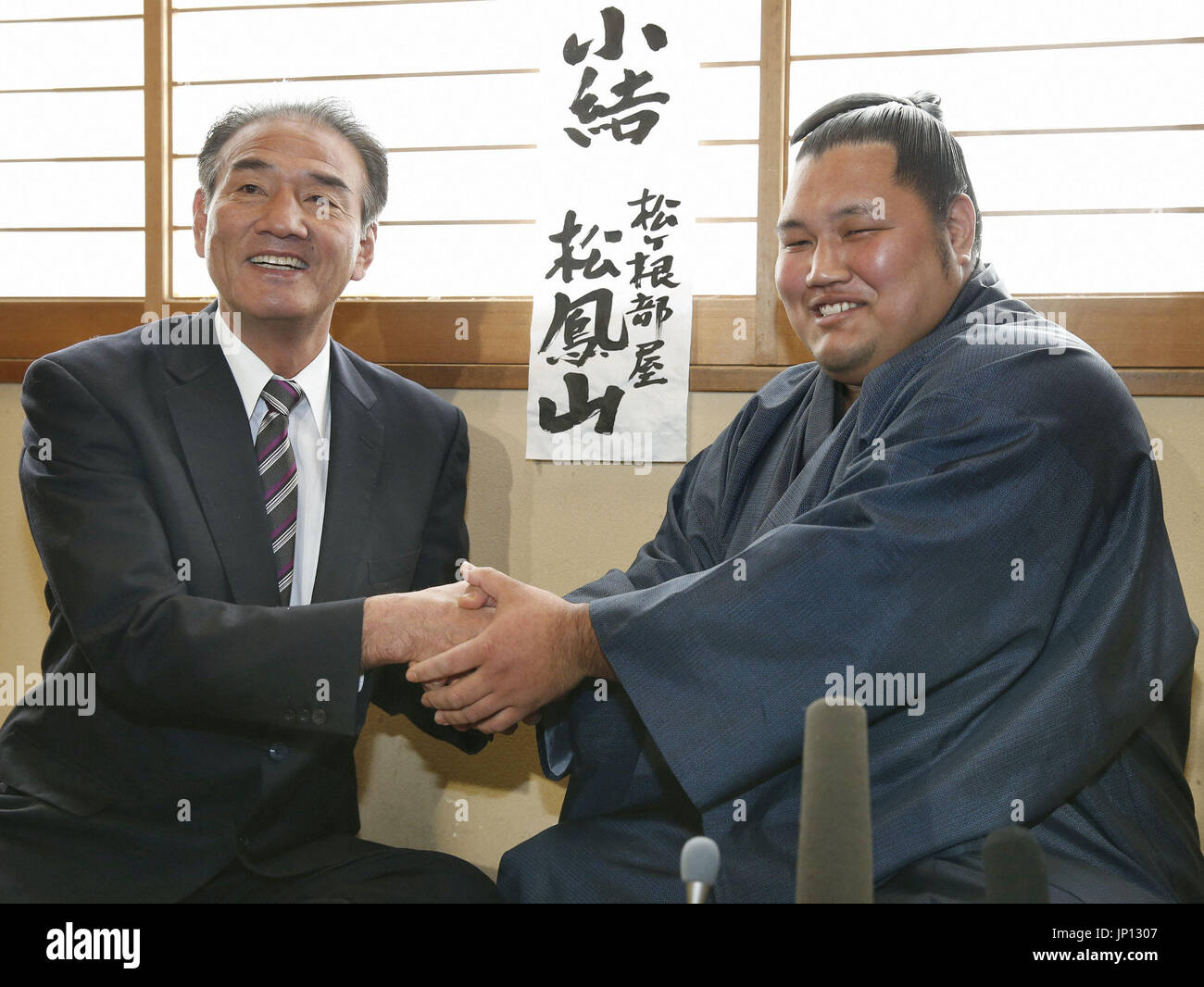 FUNABASHI, Japan - Sumo wrestler Shohozan (R) shakes hands with his ...