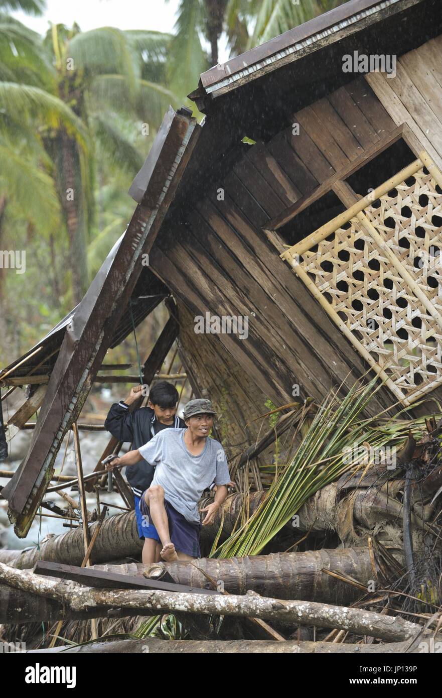 NEW BATAAN, Philippines - Rene Diano tries to collect nails and debris ...