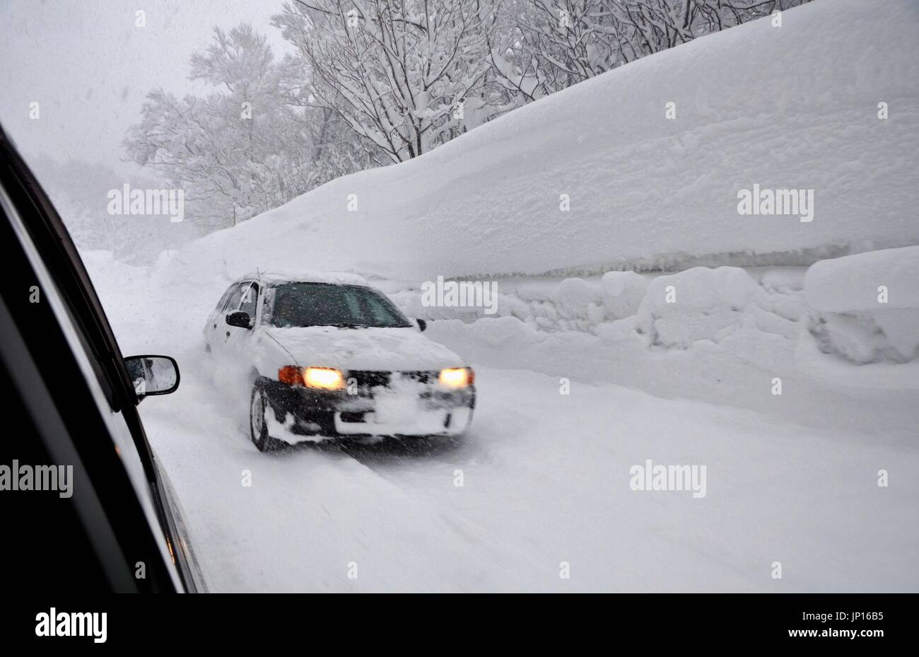 AOMORI, Japan - Photo shows a car driving on a road sandwiched by snow ...