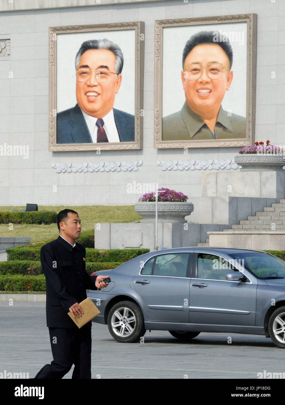 PYONGYANG, North Korea - A man walks past portraits of North Korean ...