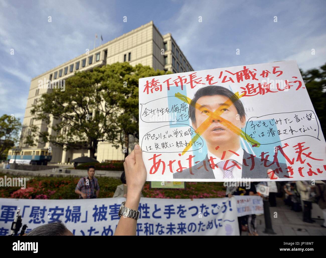 OSAKA, Japan - People hold a rally in front of the Osaka city offices ...