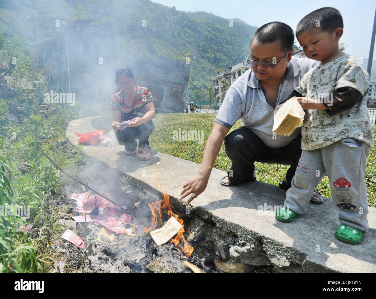 BEICHUAN, China - Mourners Chen Yuhong, his wife Li Li and their son ...