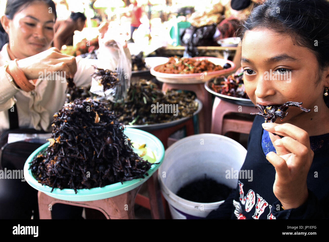 SKUON, Cambodia - A Cambodian woman (L back) sells fried tarantulas ...
