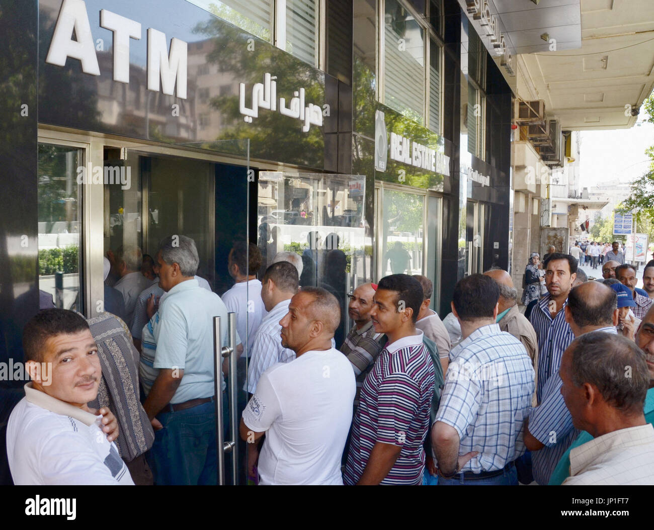 DAMASCUS, Syria - People queue in front of automated teller machines in ...