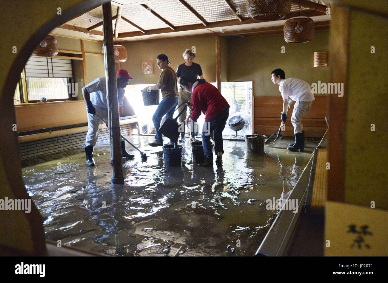 KYOTO, Japan - People clean up mud at a traditional "ryotei" Japanese ...