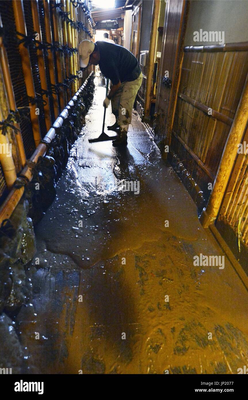KYOTO, Japan - A man cleans up mud at a traditional "ryotei" Japanese ...