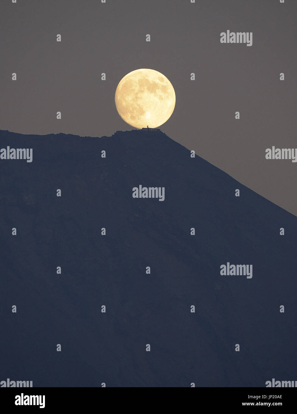 FUJINOMIYA, Japan - An almost full moon emerges over the top of Mt ...