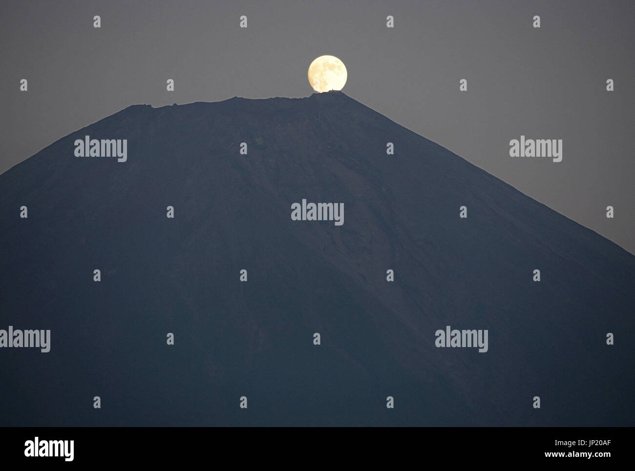 FUJINOMIYA, Japan - An almost full moon emerges over the top of Mt ...