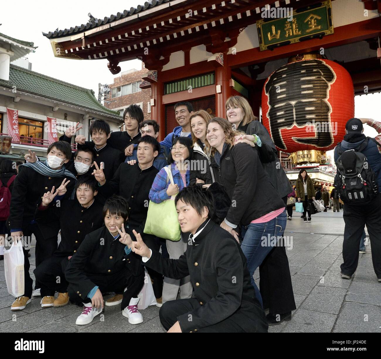 TOKYO, Japan - Foreign tourists pose with Japanese students on a school ...