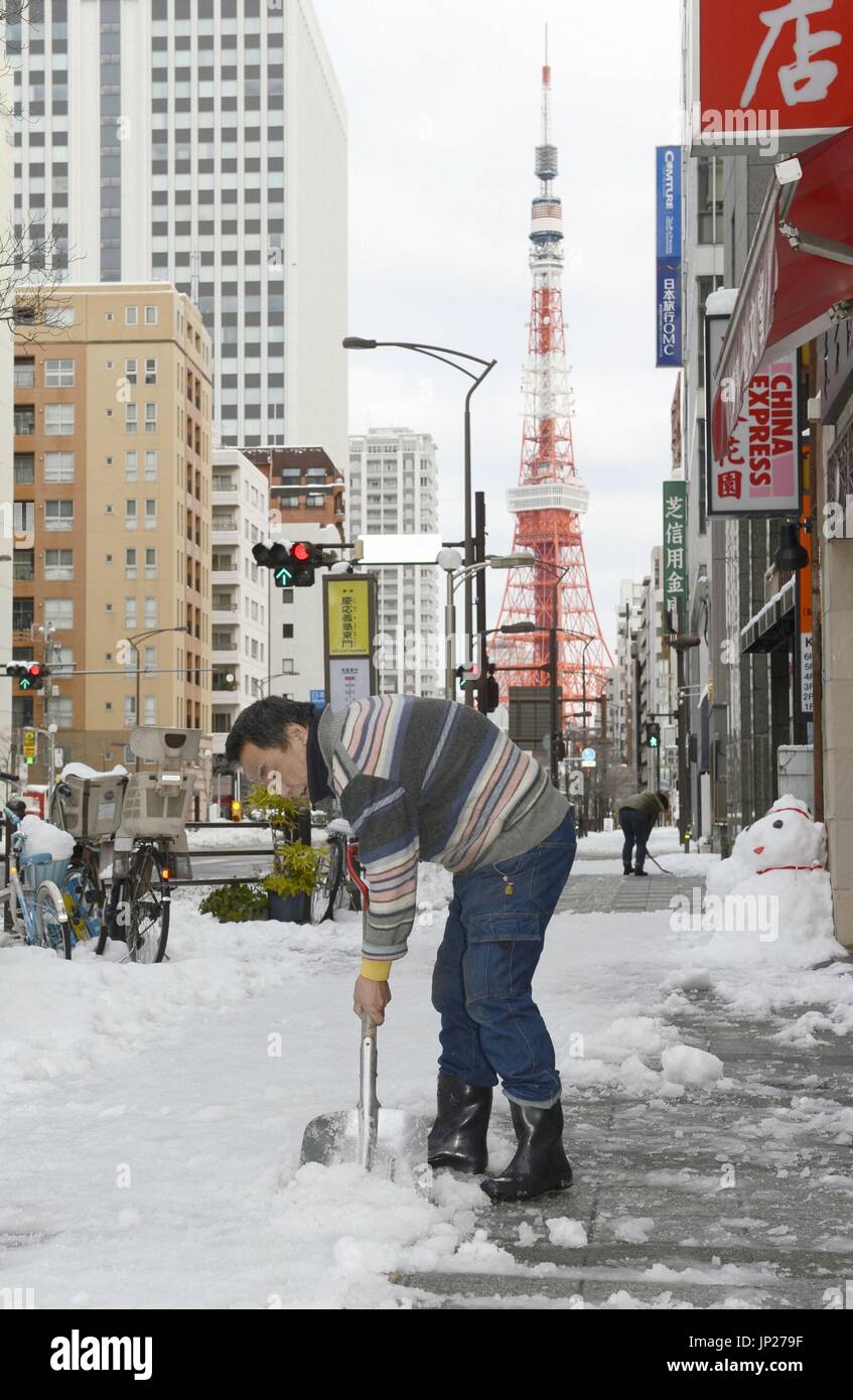 TOKYO, Japan - A man removes snow on a street in Tokyo's Minato Ward on ...