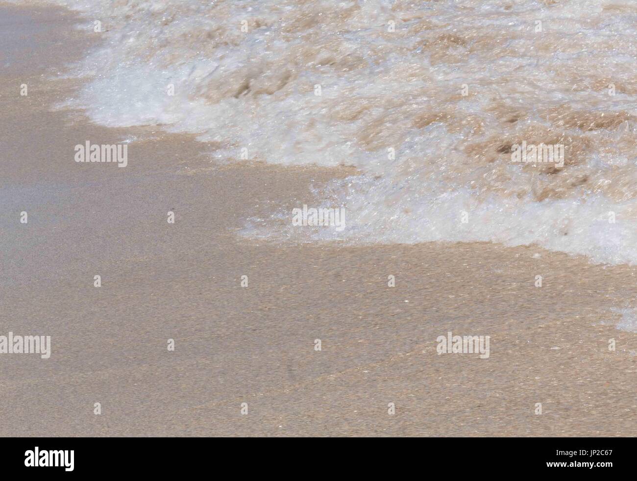 Ocean water coming onto beach sand Stock Photo - Alamy