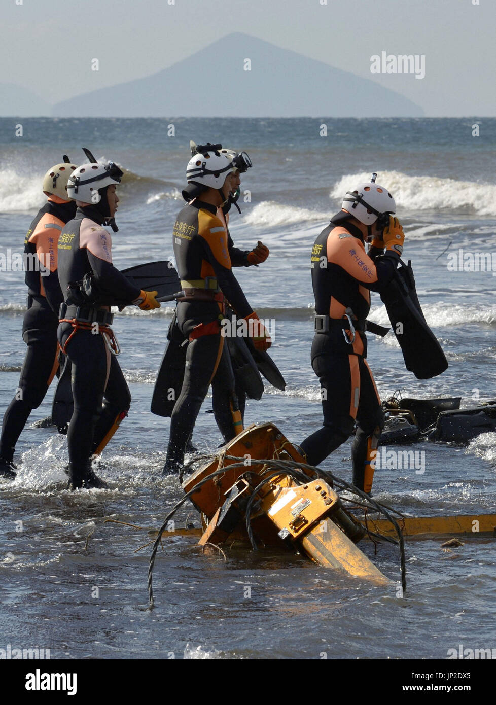 OSHIMA, Japan - Japan Coast Guard divers head for a search and rescue ...