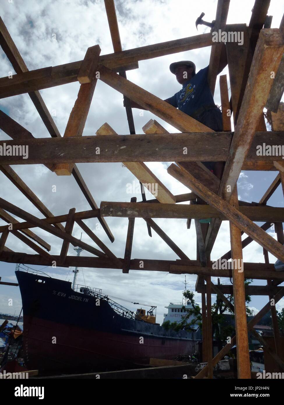 TACLOBAN CITY, Philippines - A Filipino carpenter works on a new wooden ...