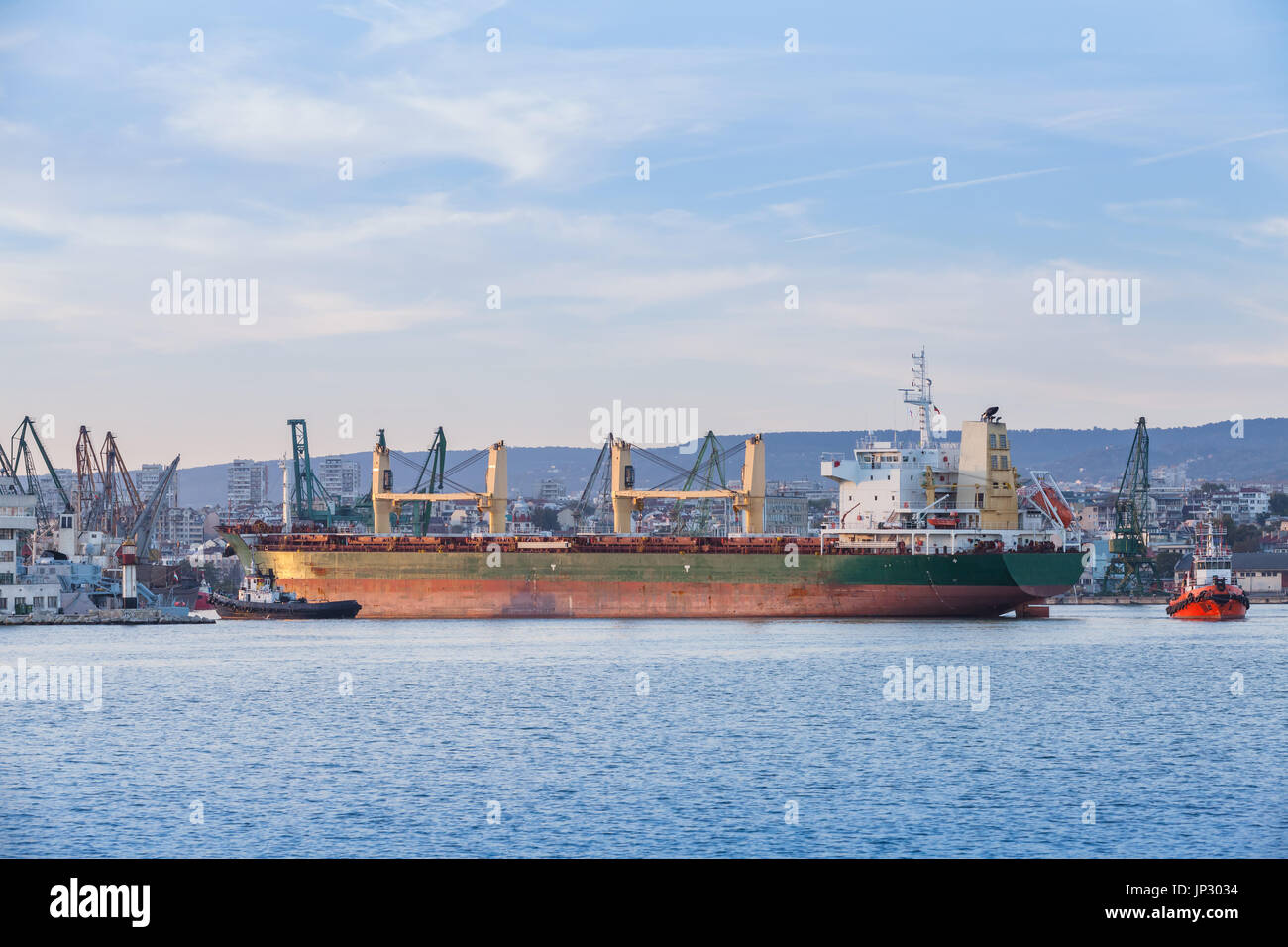 Bulk carrier, industrial ship with deck cranes loading in port of Varna ...