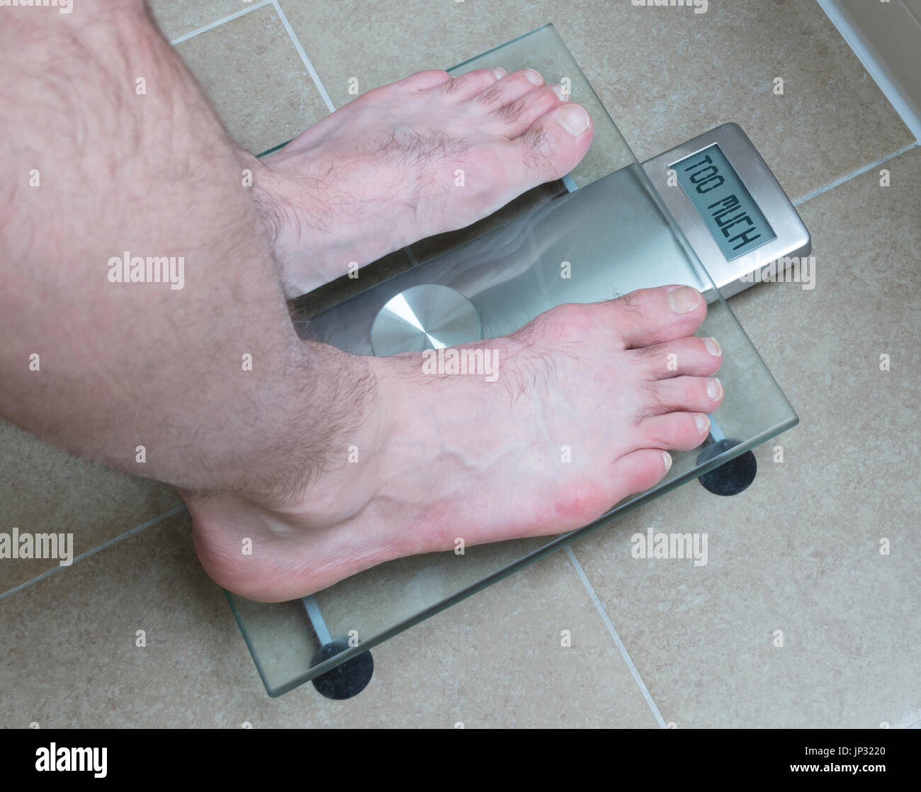 Closeup of man's feet on weight scale - Too much Stock Photo - Alamy