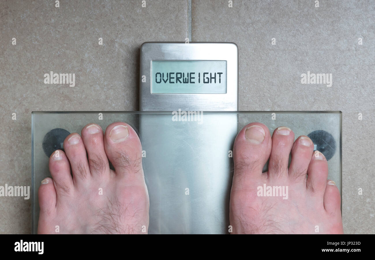 Closeup of man's feet on weight scale - Overweight Stock Photo - Alamy