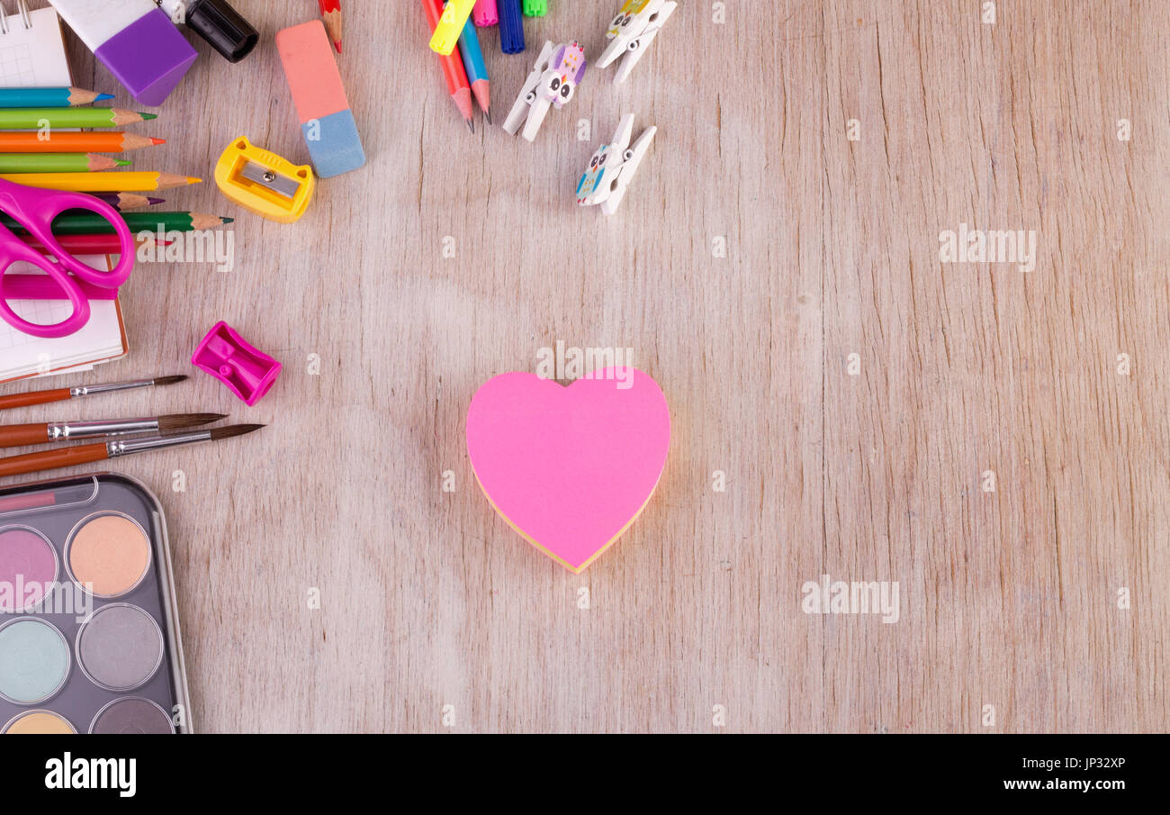 Top view of school supplies on wooden desk. Heart shaped stickers for ...