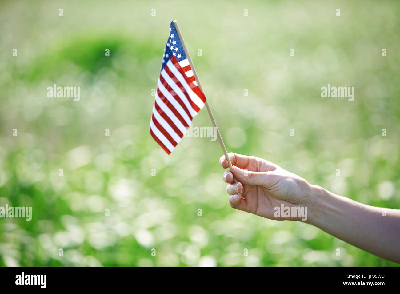 Human hand holding US flag for Independence Day Stock Photo - Alamy