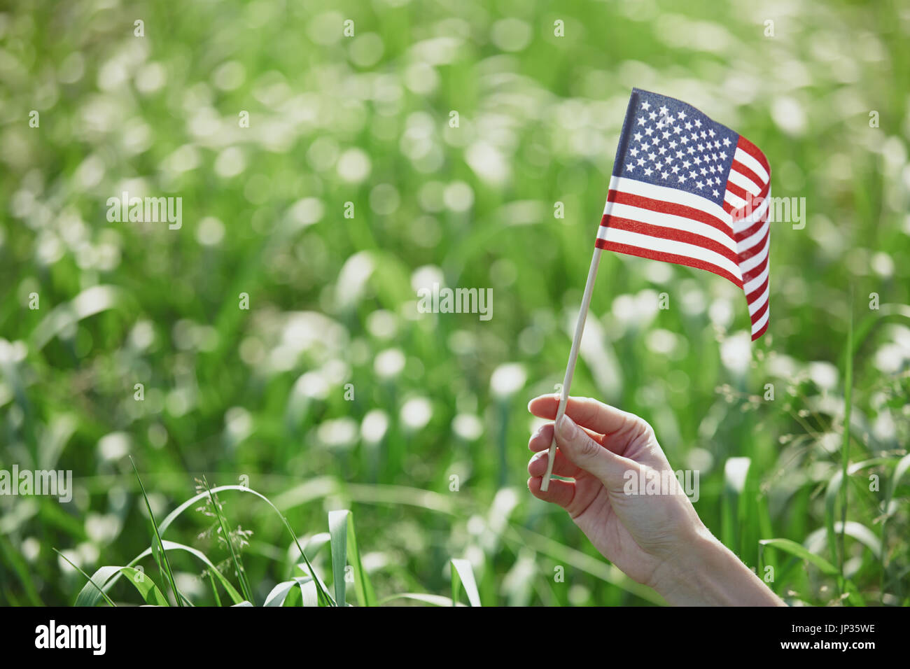 Human hand holding US flag for Independence Day Stock Photo - Alamy