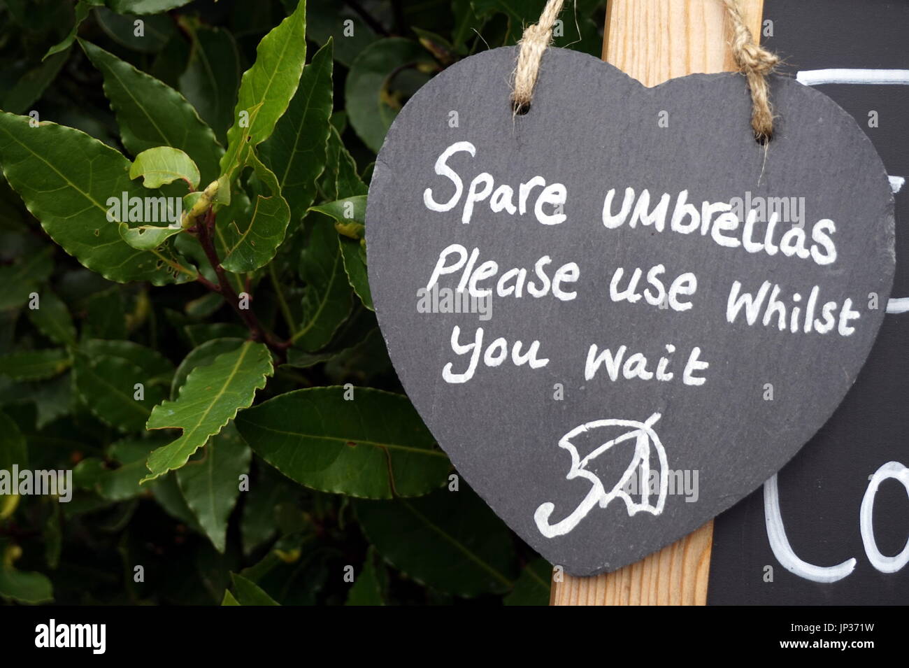 Slate heart shaped sign saying "Spare umbrellas Please use whilst you ...