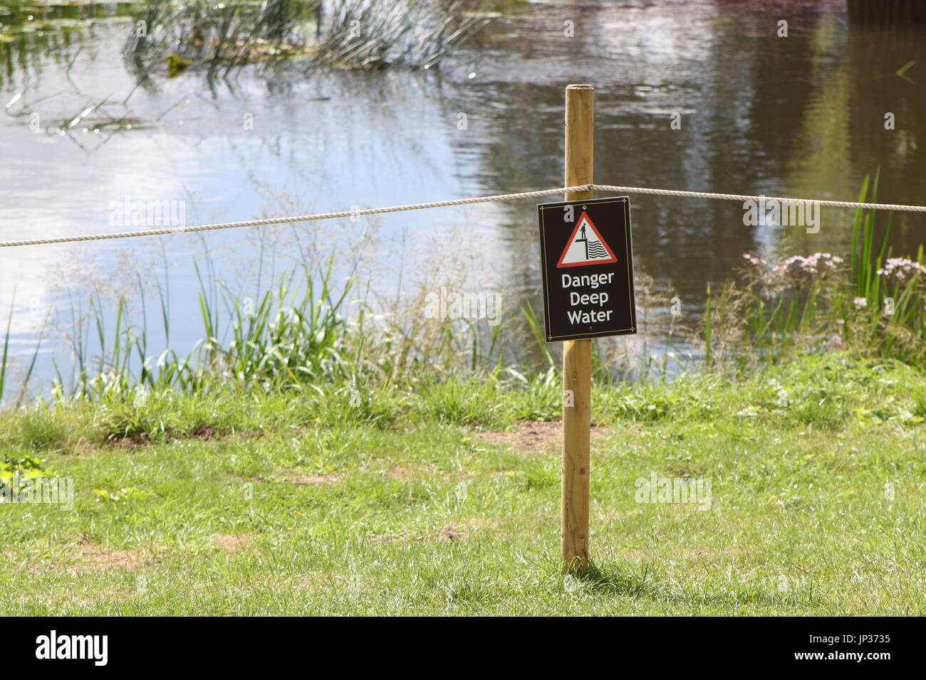 Notice on a post in front of a roped off river or lake saying "Danger ...