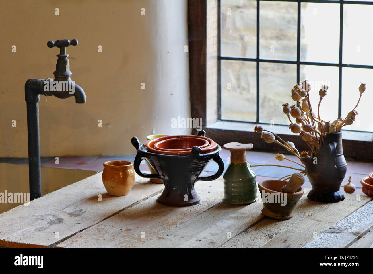 Old fashioned brass standpipe water tap or fawcett, over a wooden bench ...