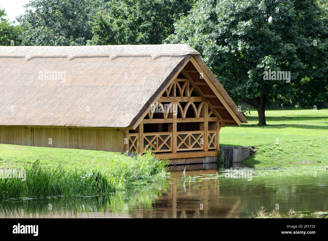 Pretty tudor style wooden framed thatch boathouse in a wood on the edge ...