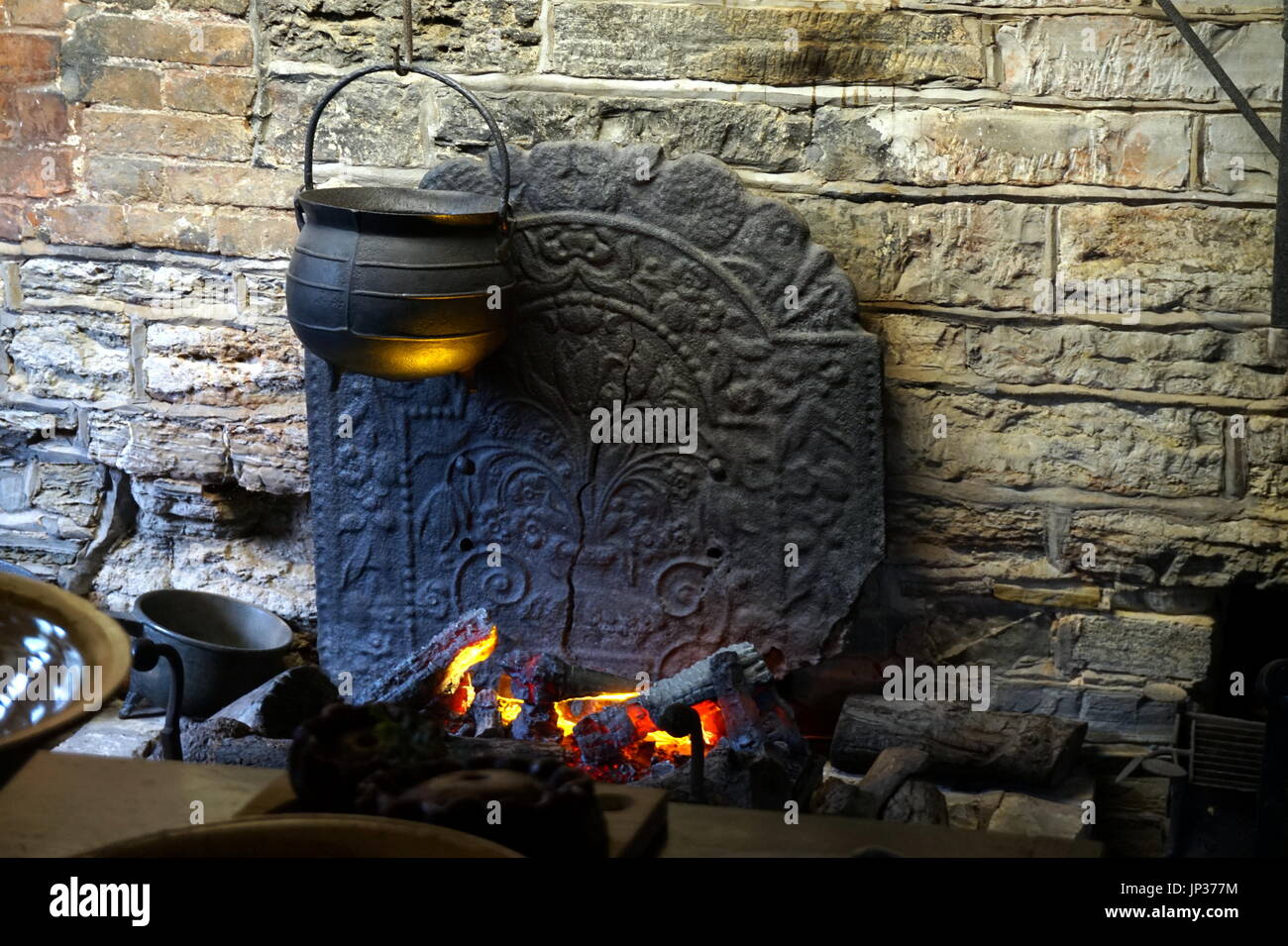 Traditional old antique pots and pans over a log fire with ornate ...
